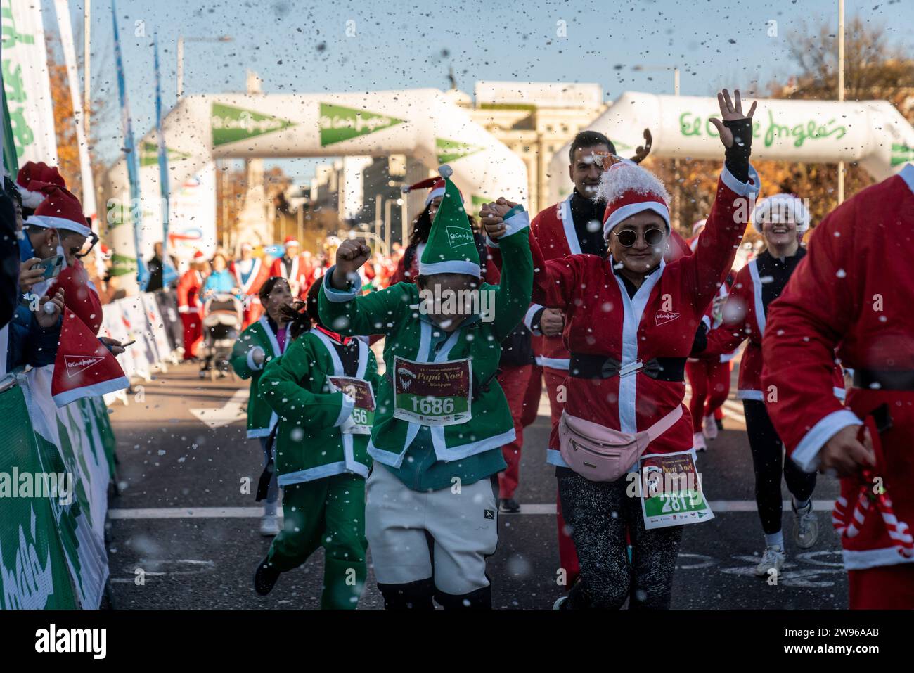 Participants dressed as Santa Claus arrive at the finish line during ...