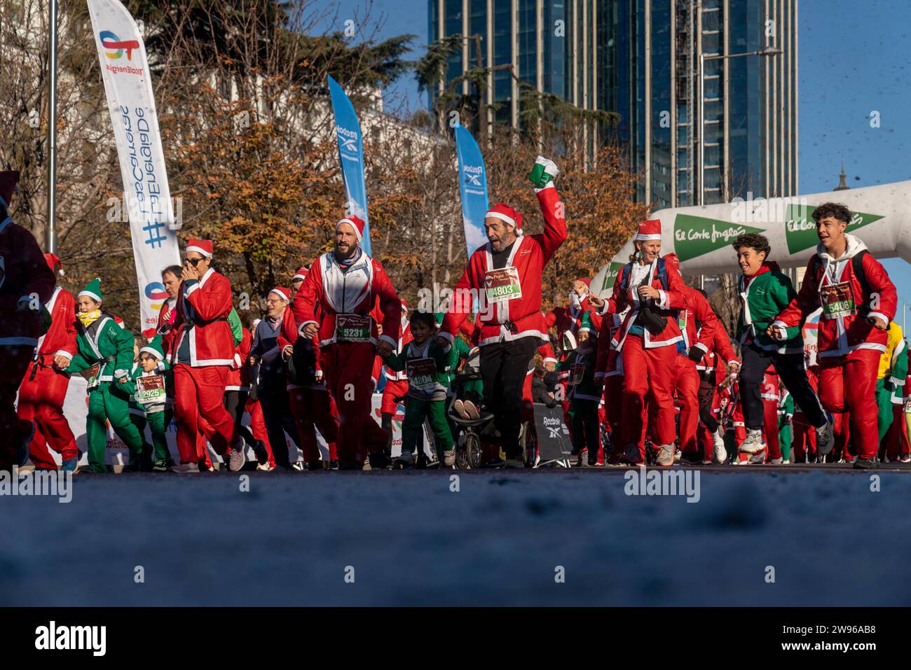 Participants dressed as Santa Claus arrive at the finish line during ...