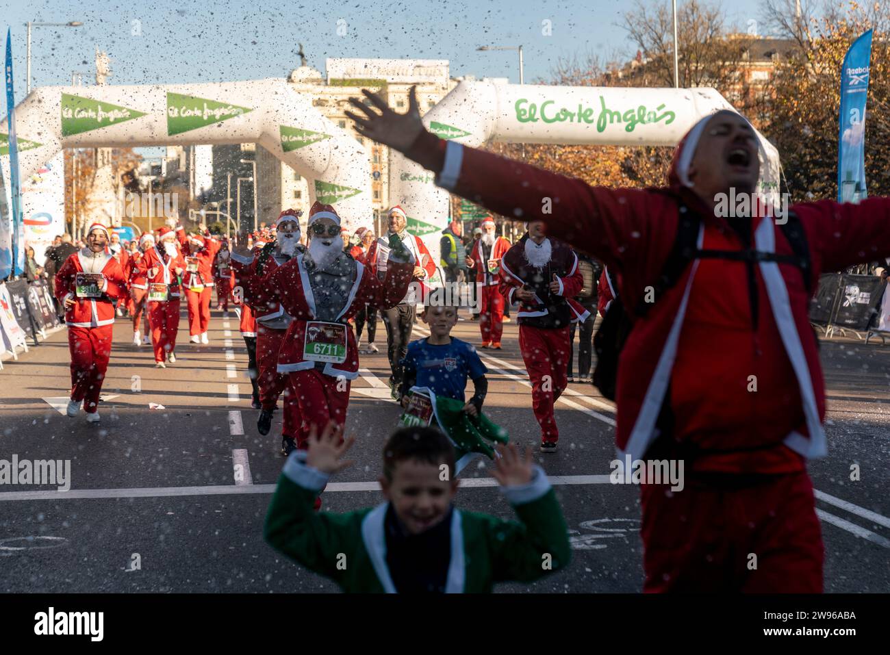 Participants dressed as Santa Claus arrive at the finish line during ...