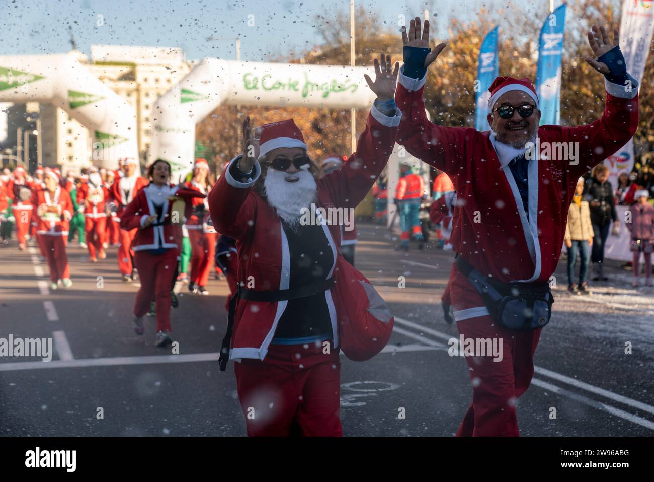 Participants dressed as Santa Claus arrive at the finish line during ...
