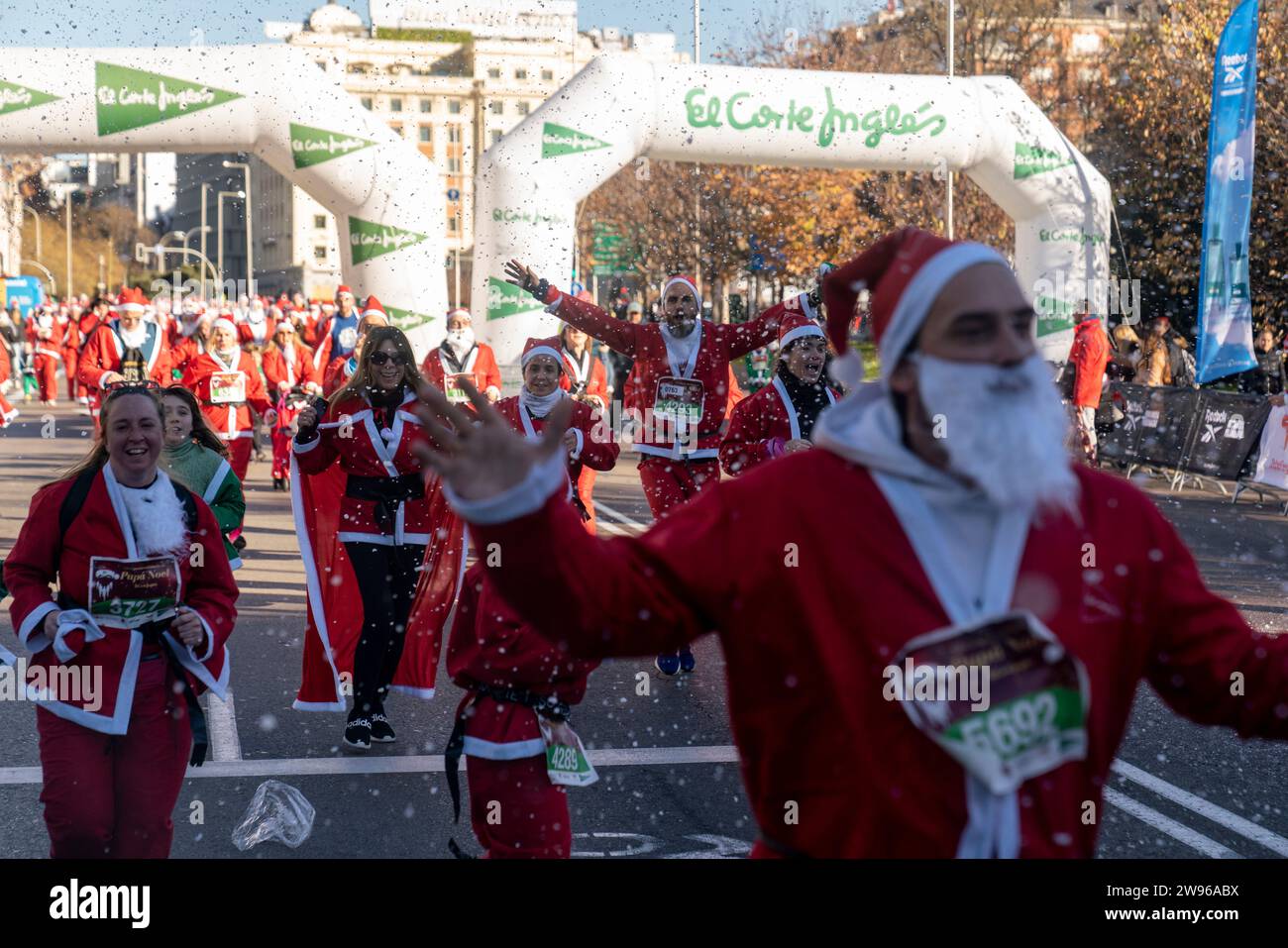 Participants dressed as Santa Claus arrive at the finish line during ...