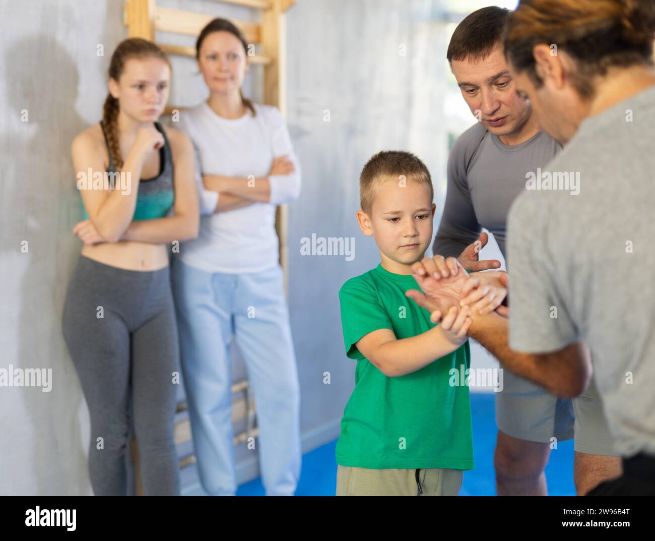 Boy in krav maga lesson trains and repeats exercise of self-defense ...