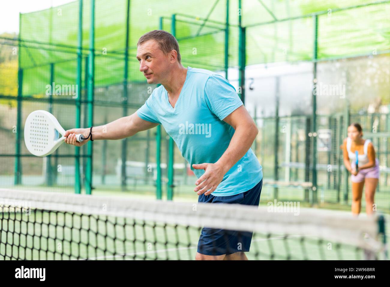 Male padel tennis player training on court. Man using racket to hit ...