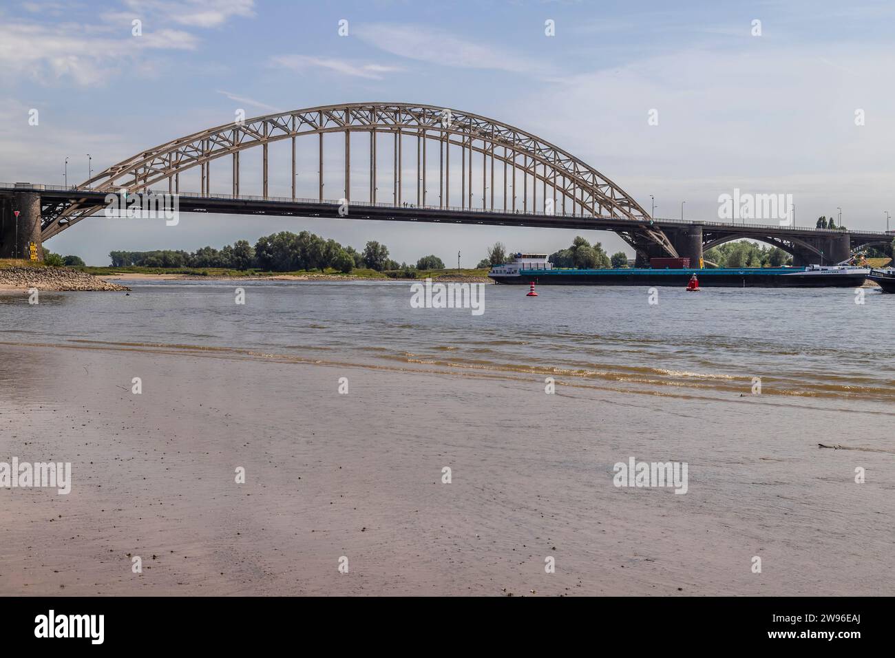 Cargo ship sails at very low tide under the Waal Bridge - Waalbrug ...