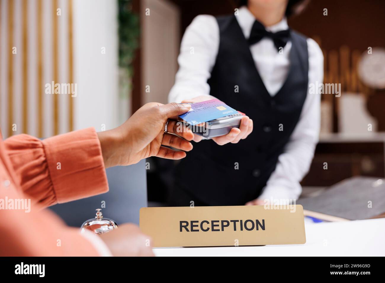 Female tourist paying at pos terminal in hotel lobby, using electronic ...