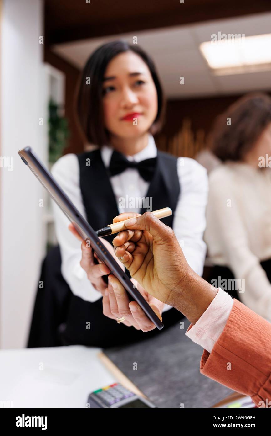 African american woman signing papers to do check in process with ...