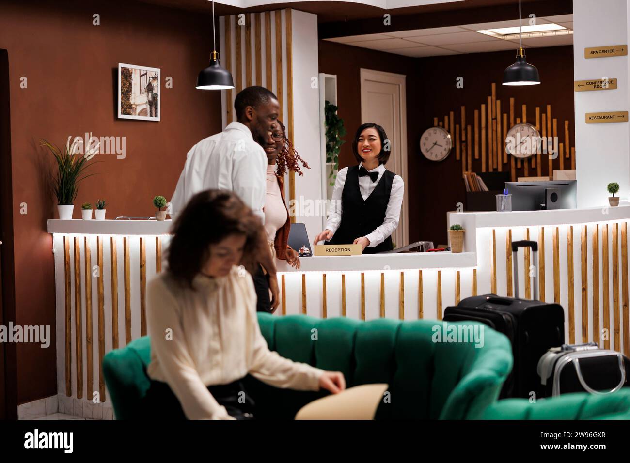 Happy couple arriving in hotel lobby and preparing to check in for room ...