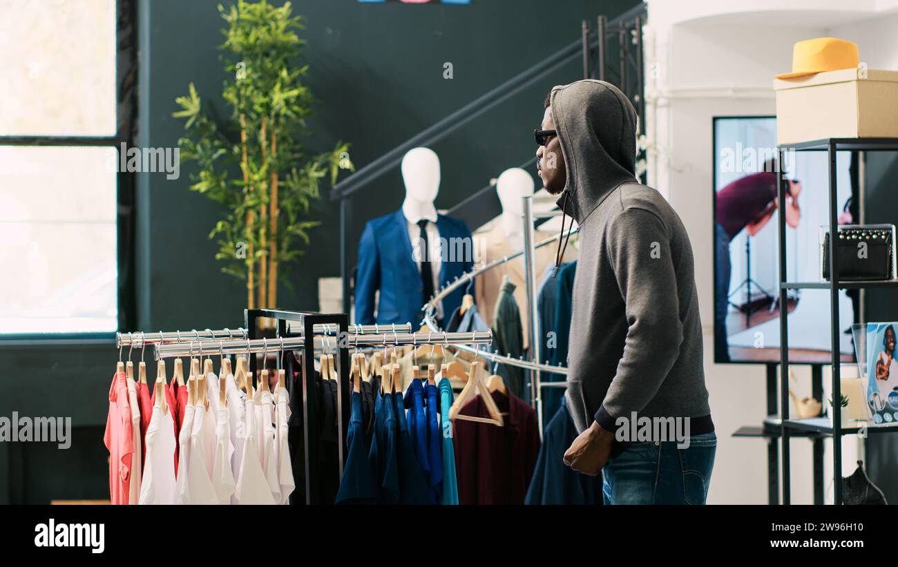African american thief trying stole trendy clothes being caught by ...