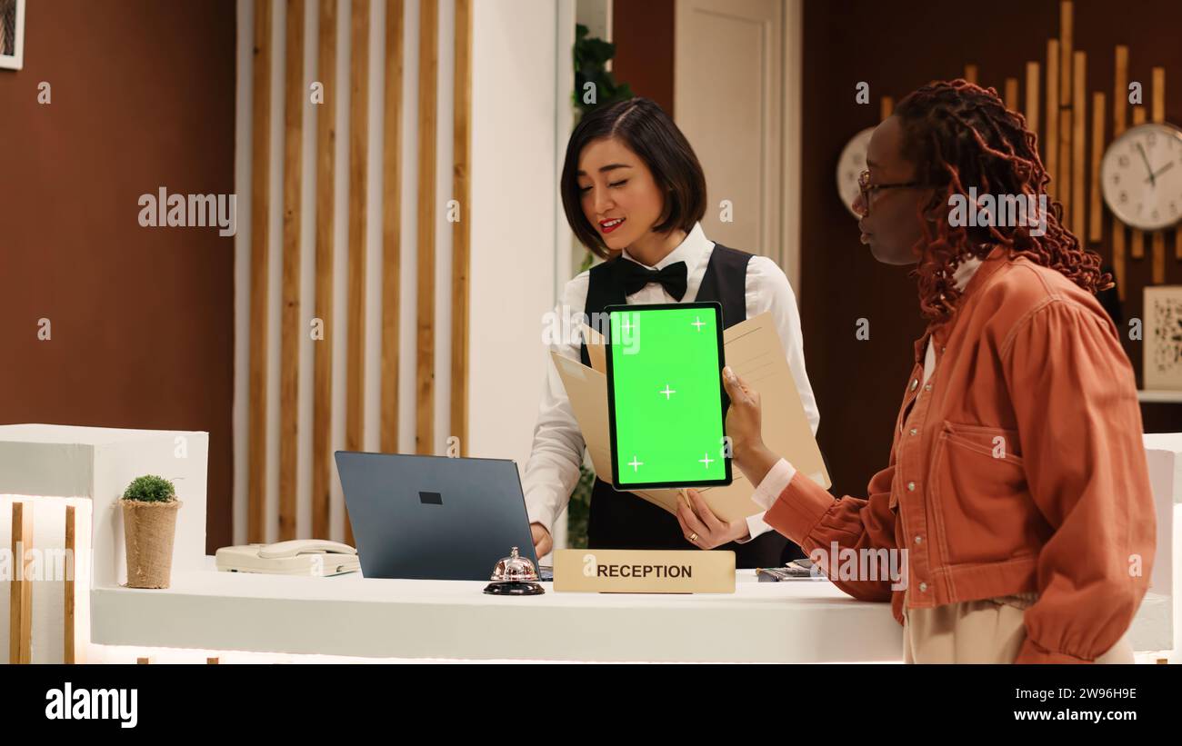 Weary tourist holding chroma key green screen mock up tablet at hotel ...