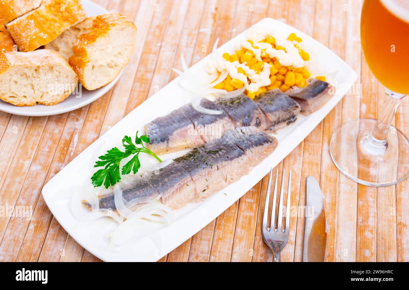 Sliced pickled herring fillet with corn and onions Stock Photo - Alamy