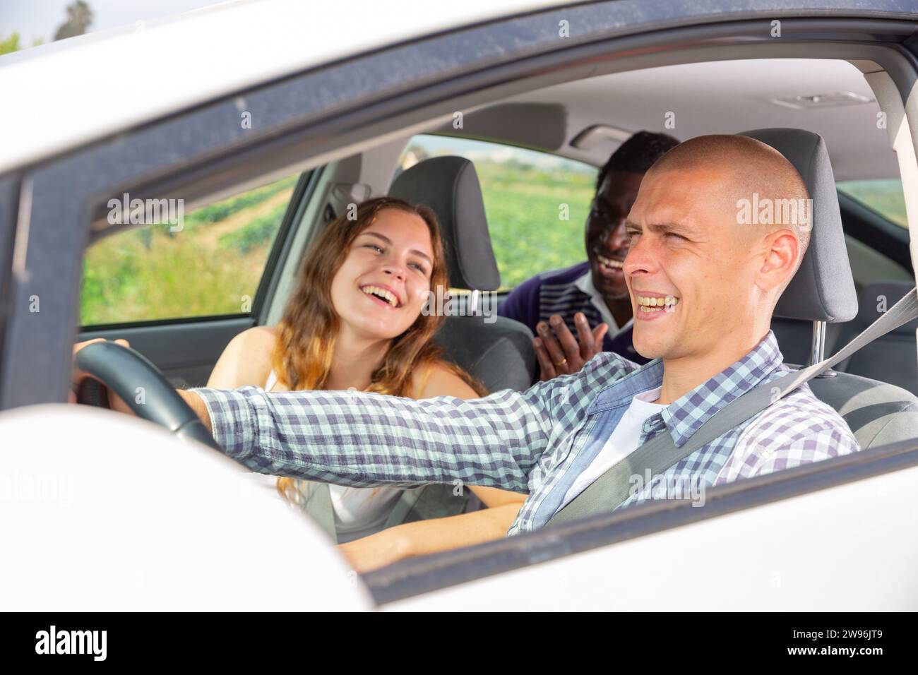 Positive friend talking in car during common trip Stock Photo - Alamy