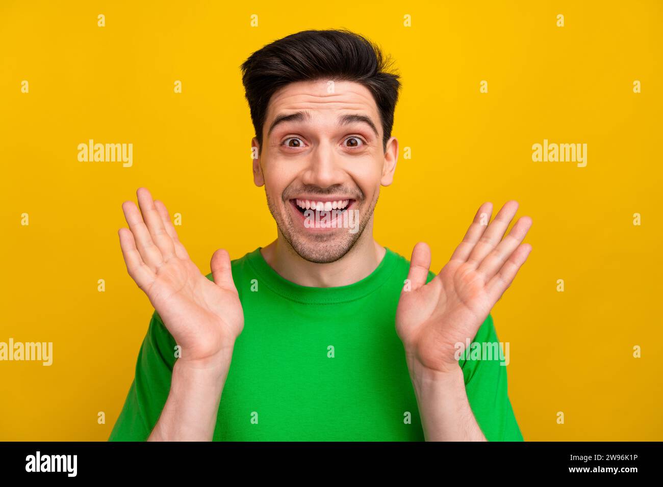 Photo portrait of nice young brunet male raise hands excited shocked ...