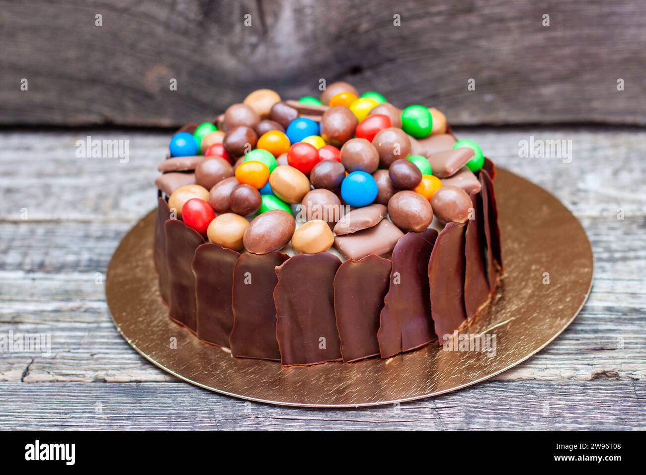 Cake with chocolate fence and scattered colorful chocolate MM bonbon on ...