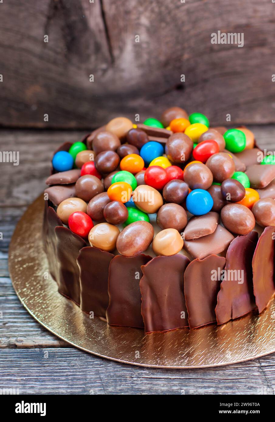 Cake with chocolate fence and scattered colorful chocolate MM bonbon on ...