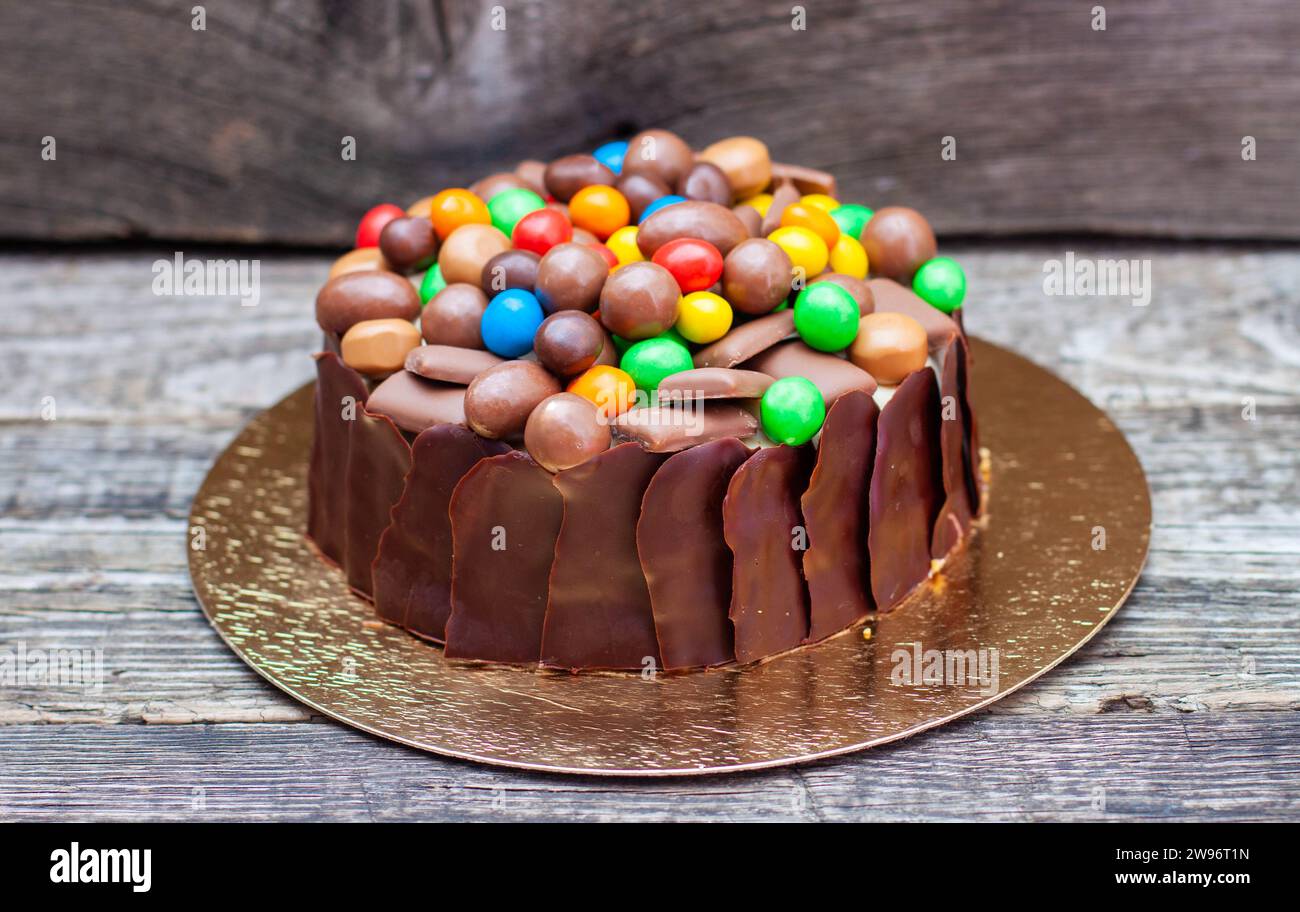Cake with chocolate fence and scattered colorful chocolate MM bonbon on ...