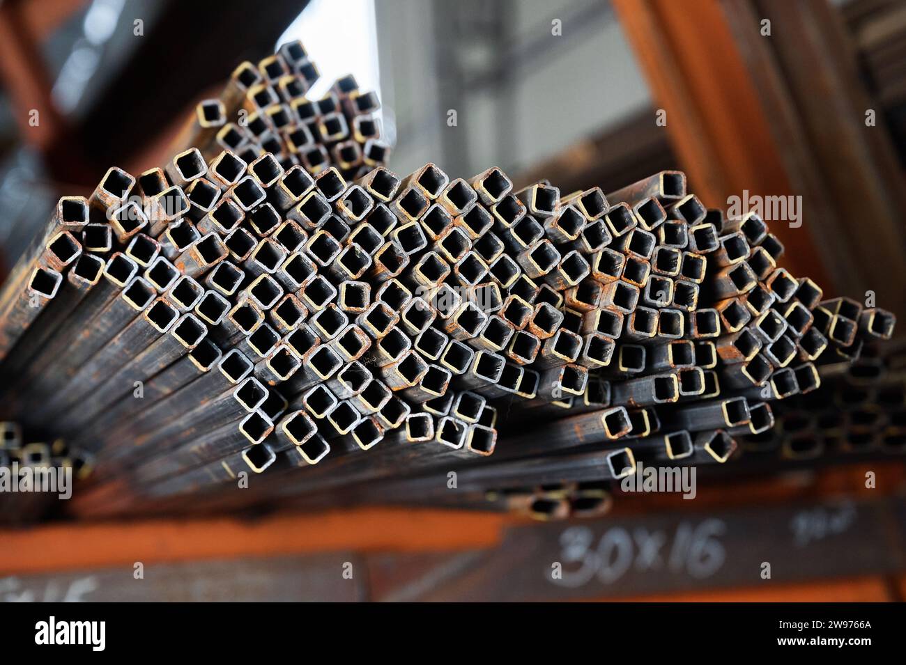 Square tubing pile on rack unit in cold factory warehouse Stock Photo ...