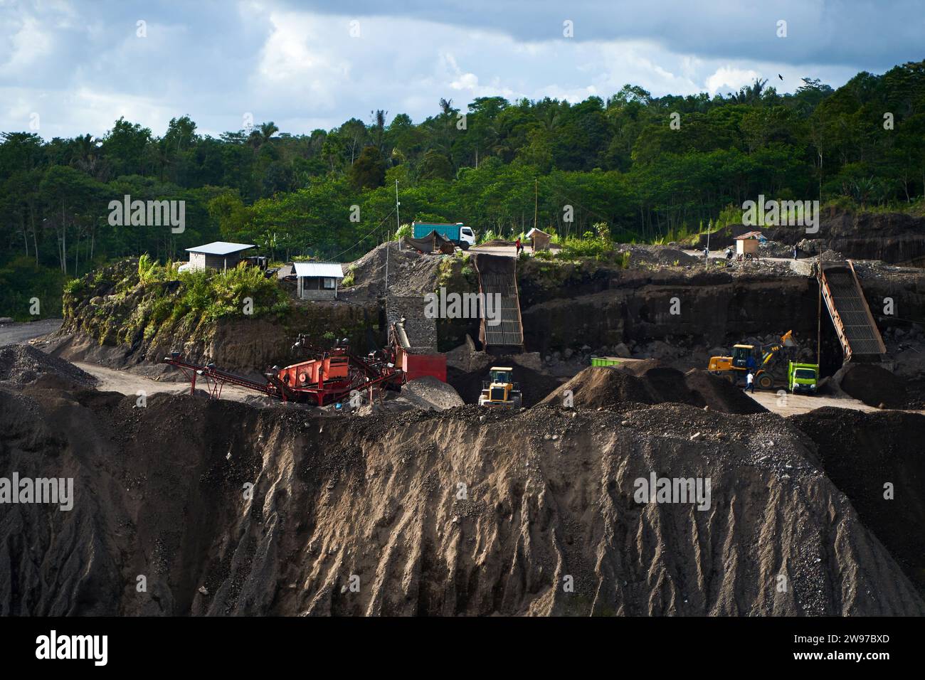 A stone quarry in Indonesia. Large equipment such as bulldozers and ...