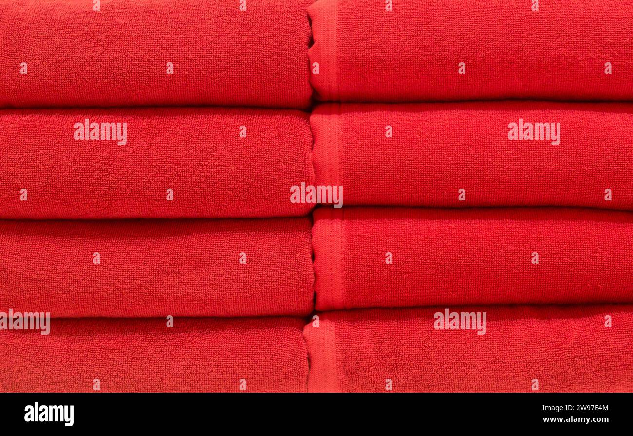 Beautiful red bath towels are tidily folded on shelves in department ...