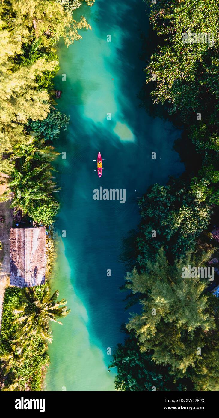 Couple men and women peddling in a kayak during the afternoon at sunset ...