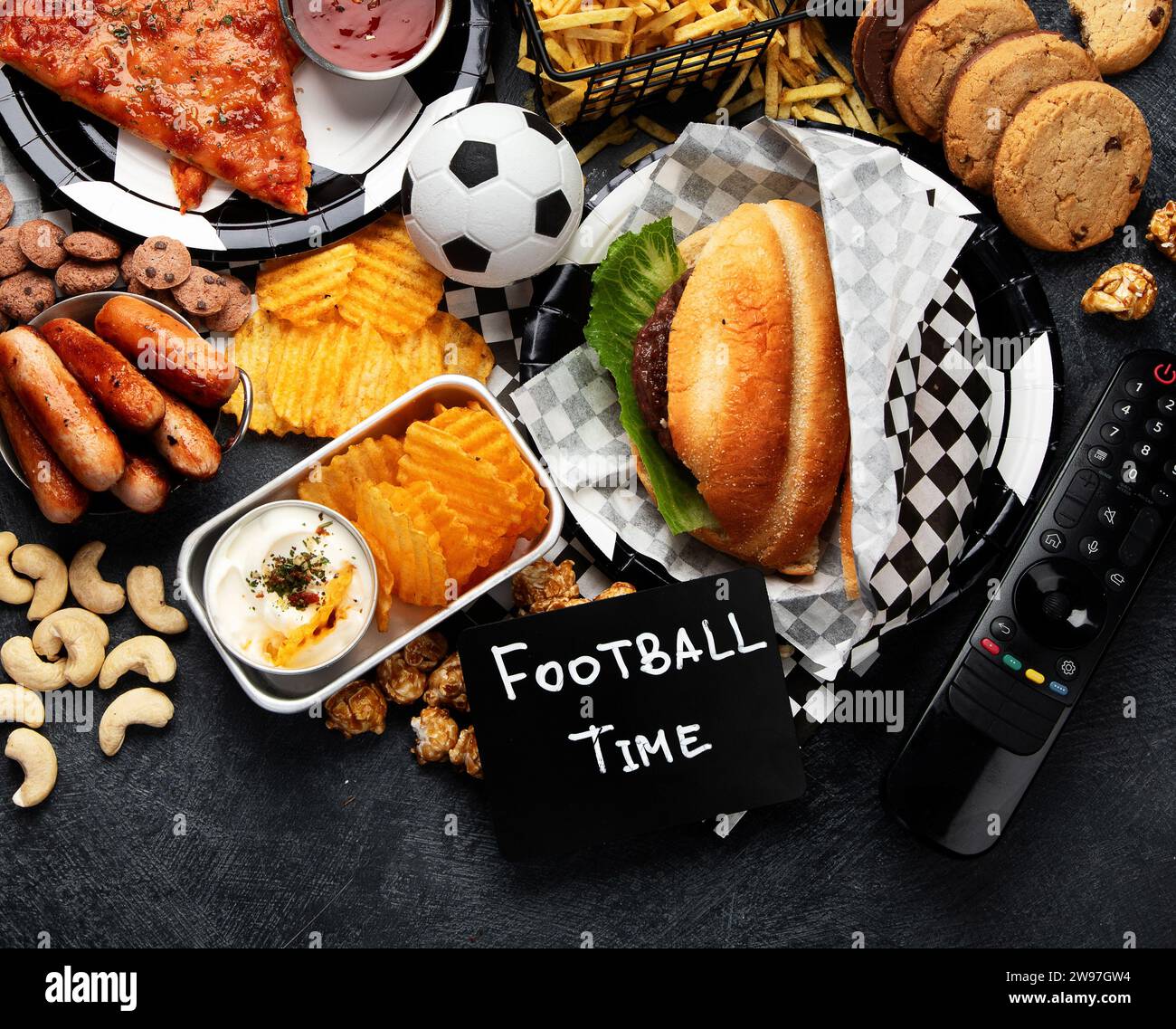 Saturated fats. Football time. TV remote control and snacks - chips ...