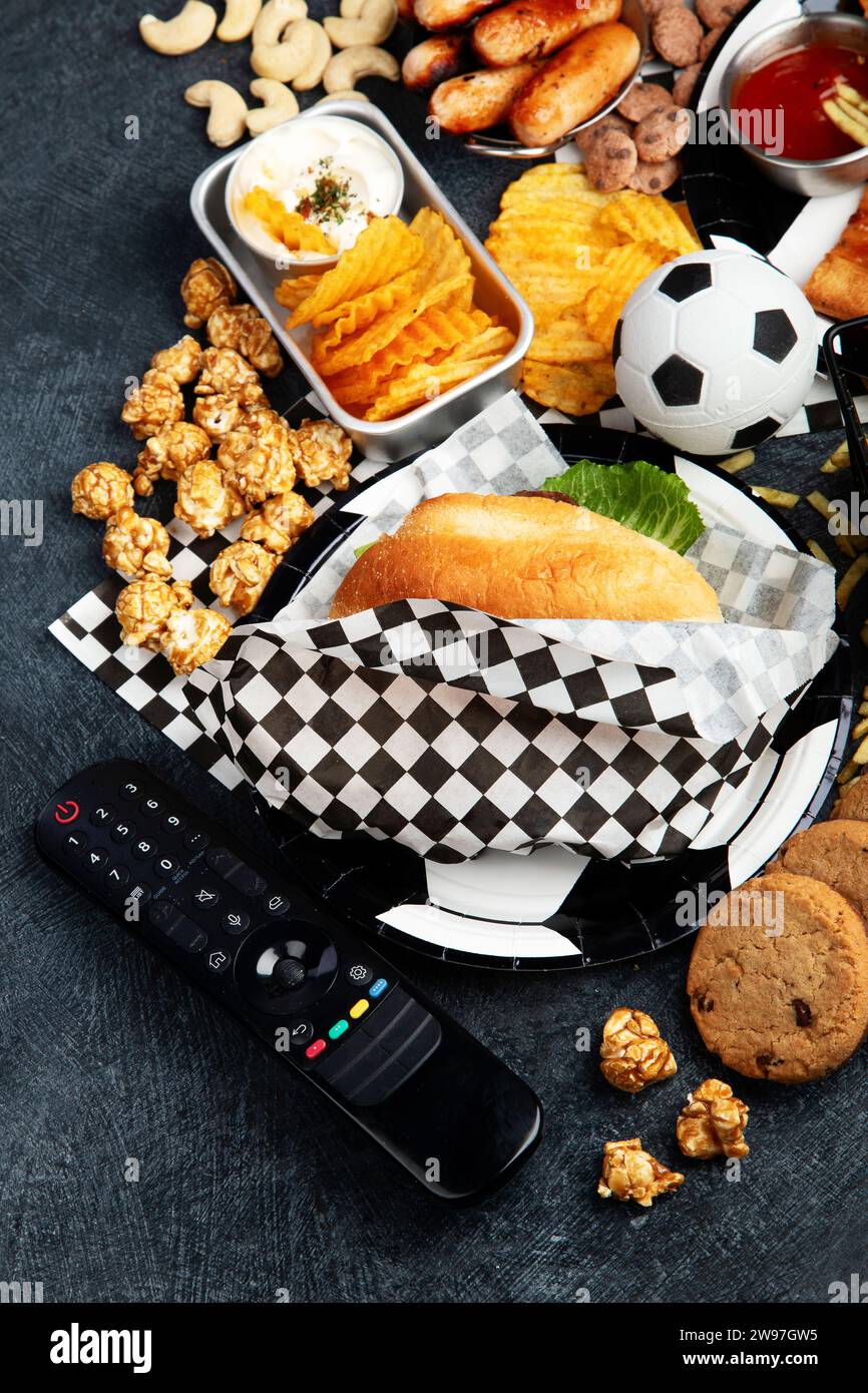 Saturated fats. Football time. TV remote control and snacks - chips ...