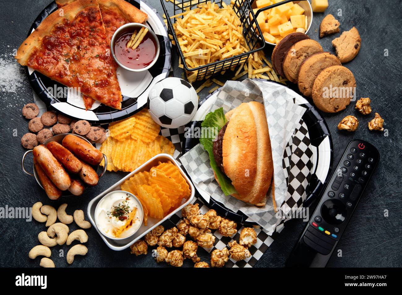 Saturated fats. Football time. TV remote control and snacks - chips ...