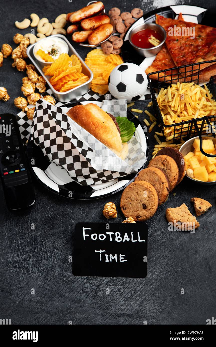 Saturated fats. Football time. TV remote control and snacks - chips ...