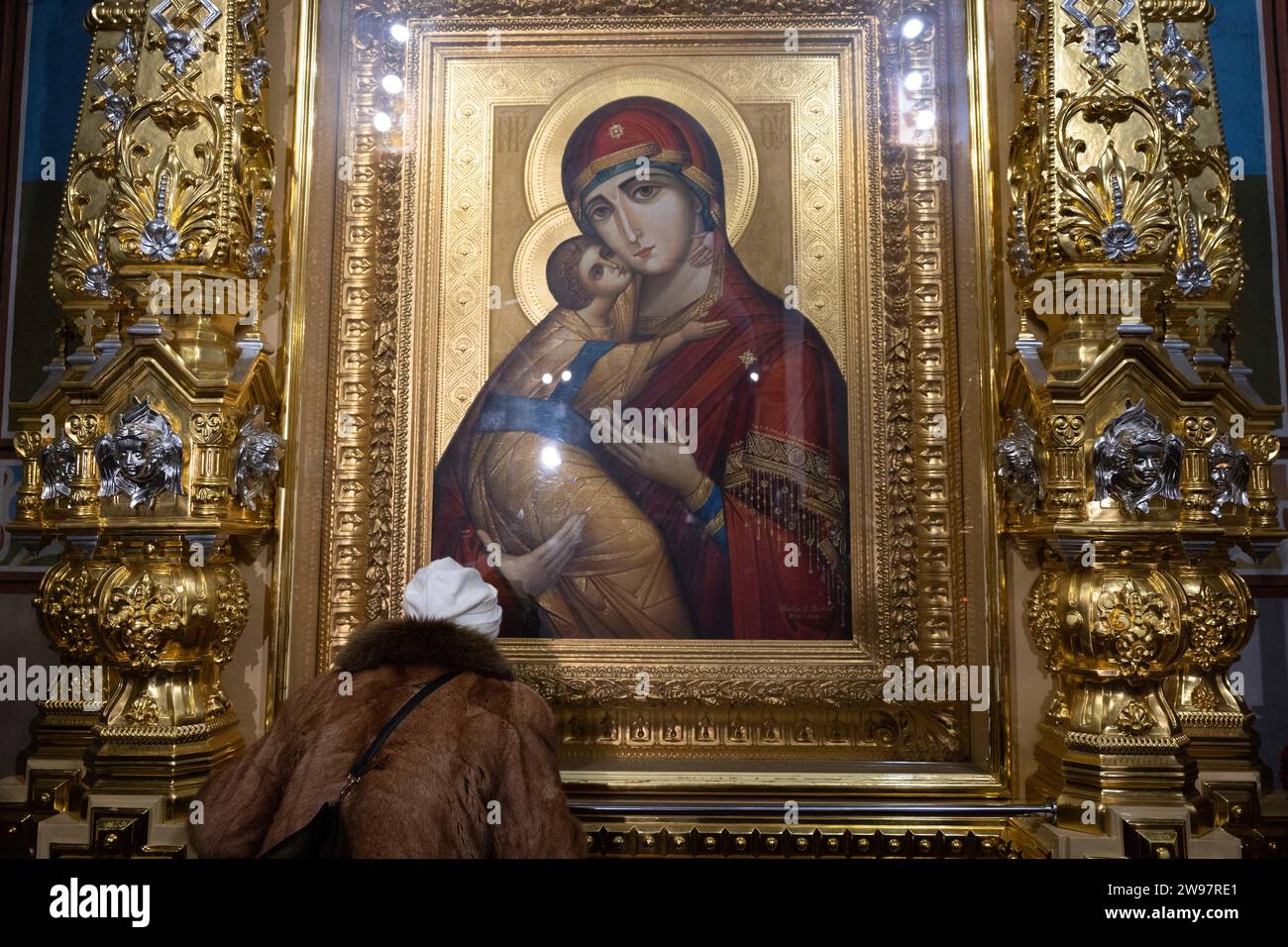 Kyiv, Ukraine. 24th Dec, 2023. A woman prays near an icon during a ...