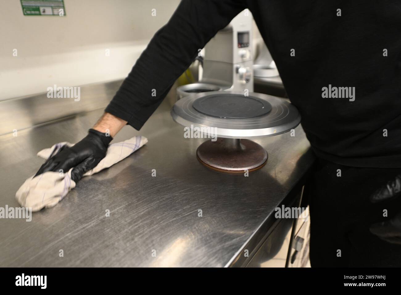 kitchen staff clean steel counter top in restaurant wearing gloves ...