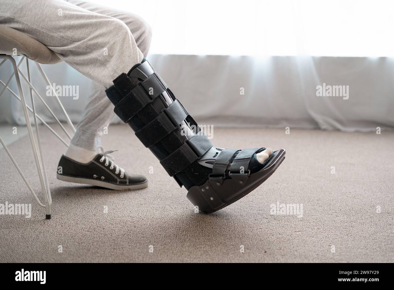 Foot orthosis concept. Close-up of man leg with ankle orthosis, black ...