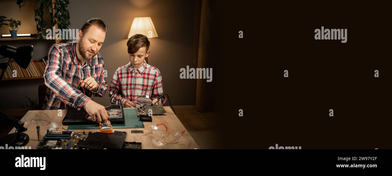 Father teaching his son to repair a broken laptop and fix the ...