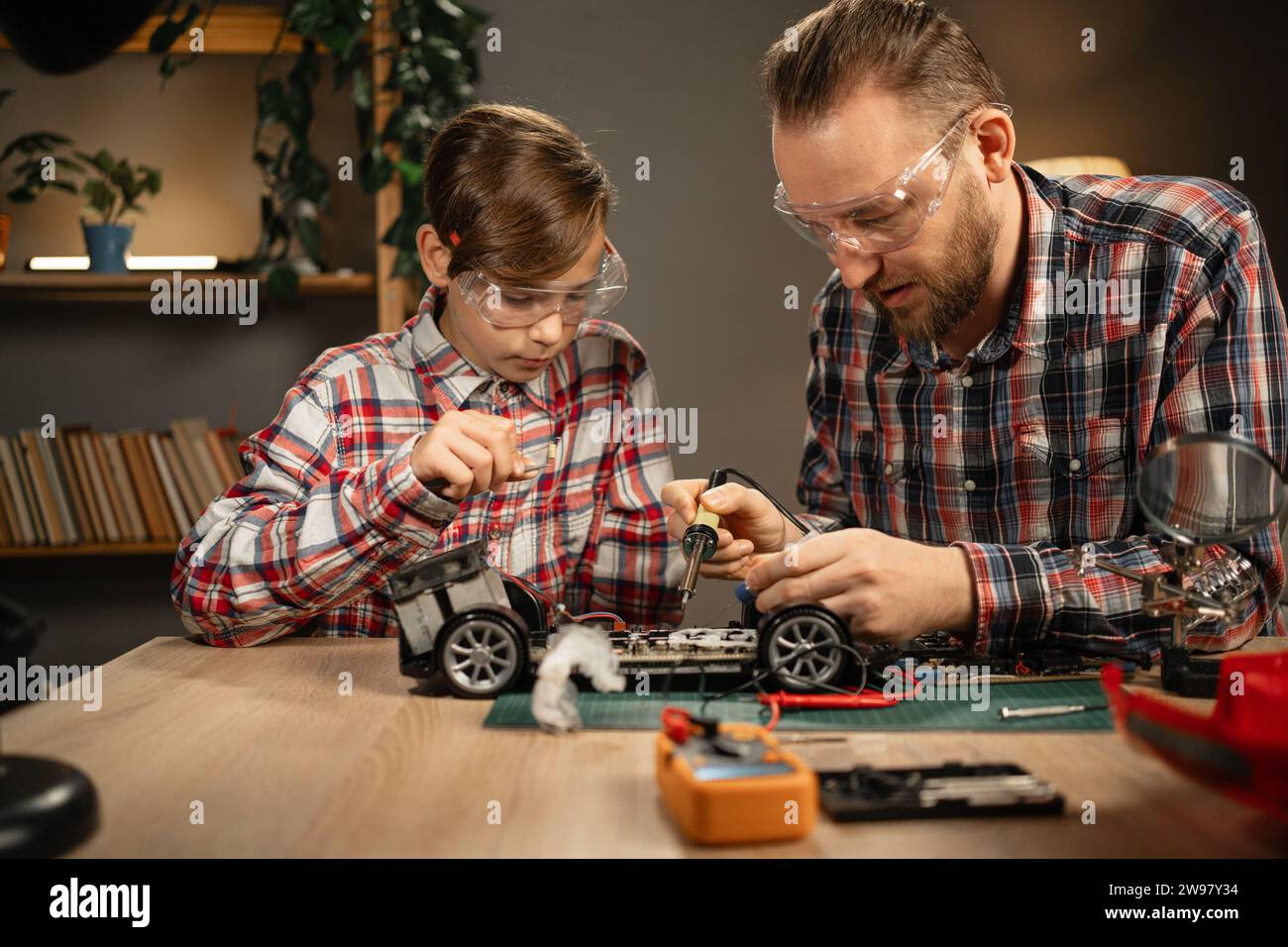 Father teaching his son for soldering remote controlled car in the ...