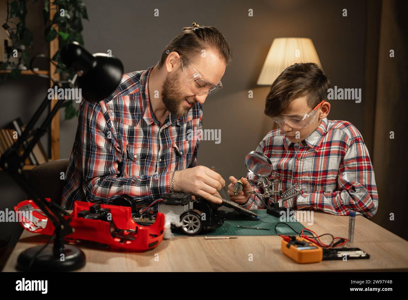 Father teaching his son for soldering remote controlled car in the ...