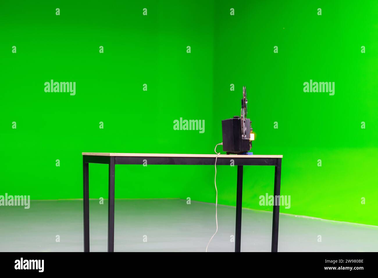 A projector on a table in a room with green walls Stock Photo - Alamy