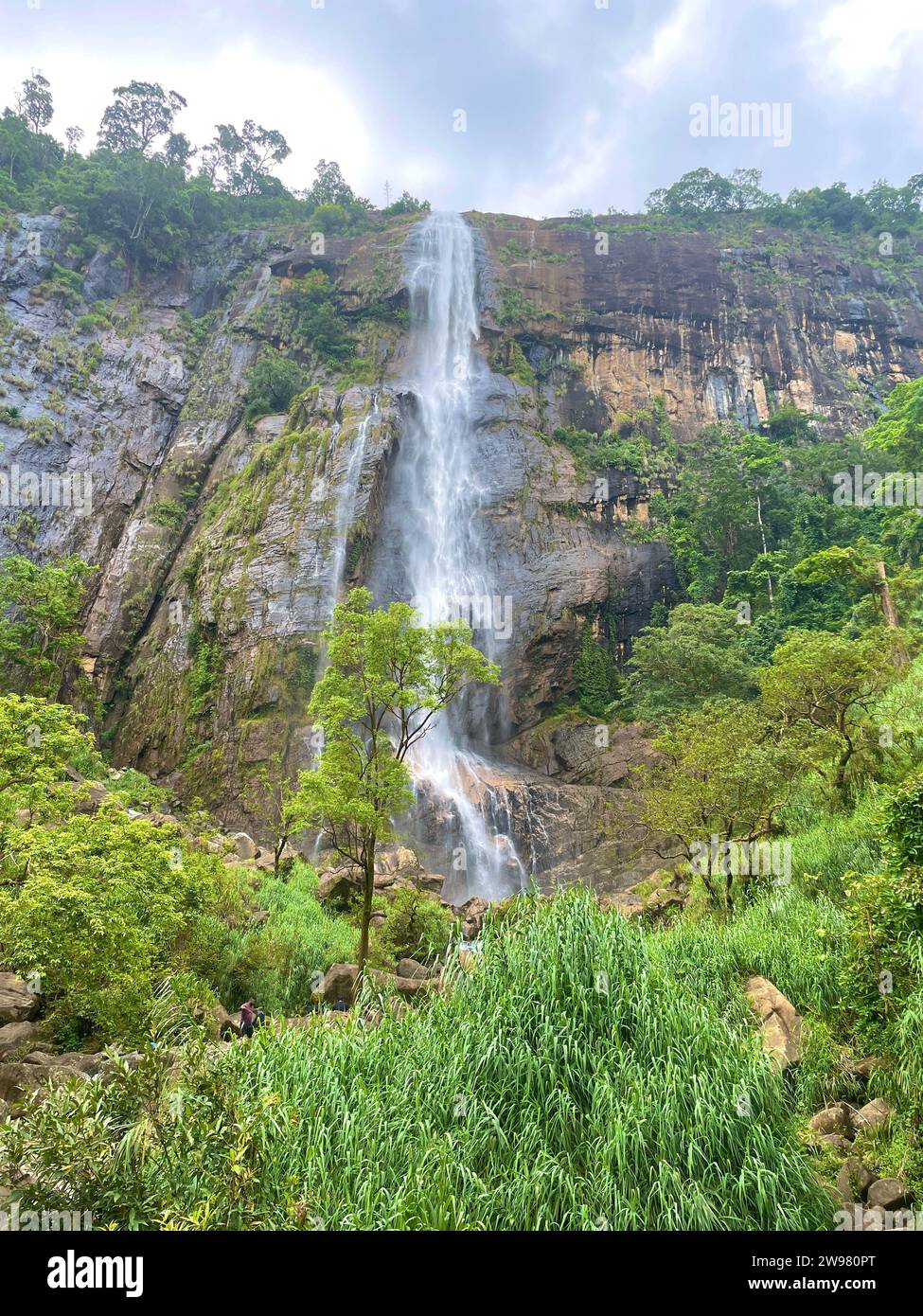 A majestic waterfall cascading down a rocky cliff face, surrounded by ...
