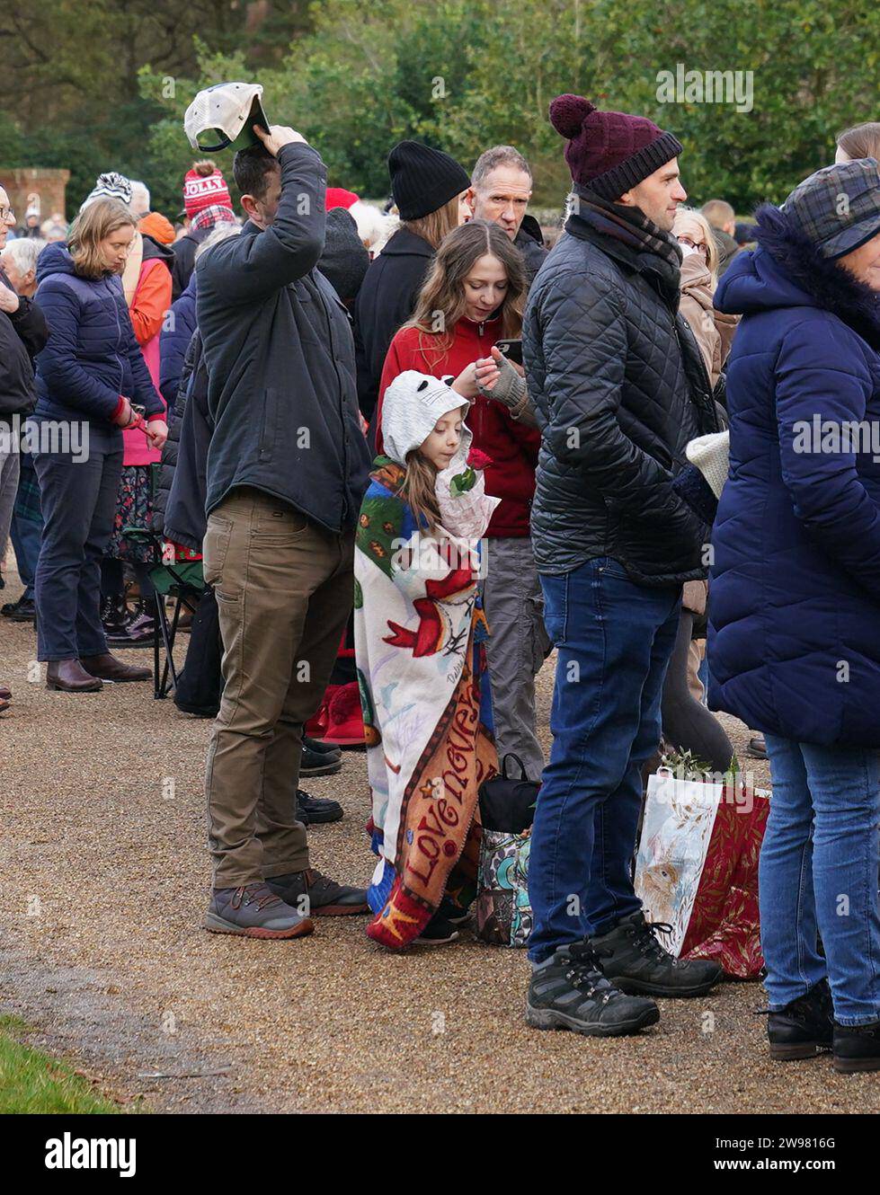 Well-wishers wait to greet the members of the royal family attending ...