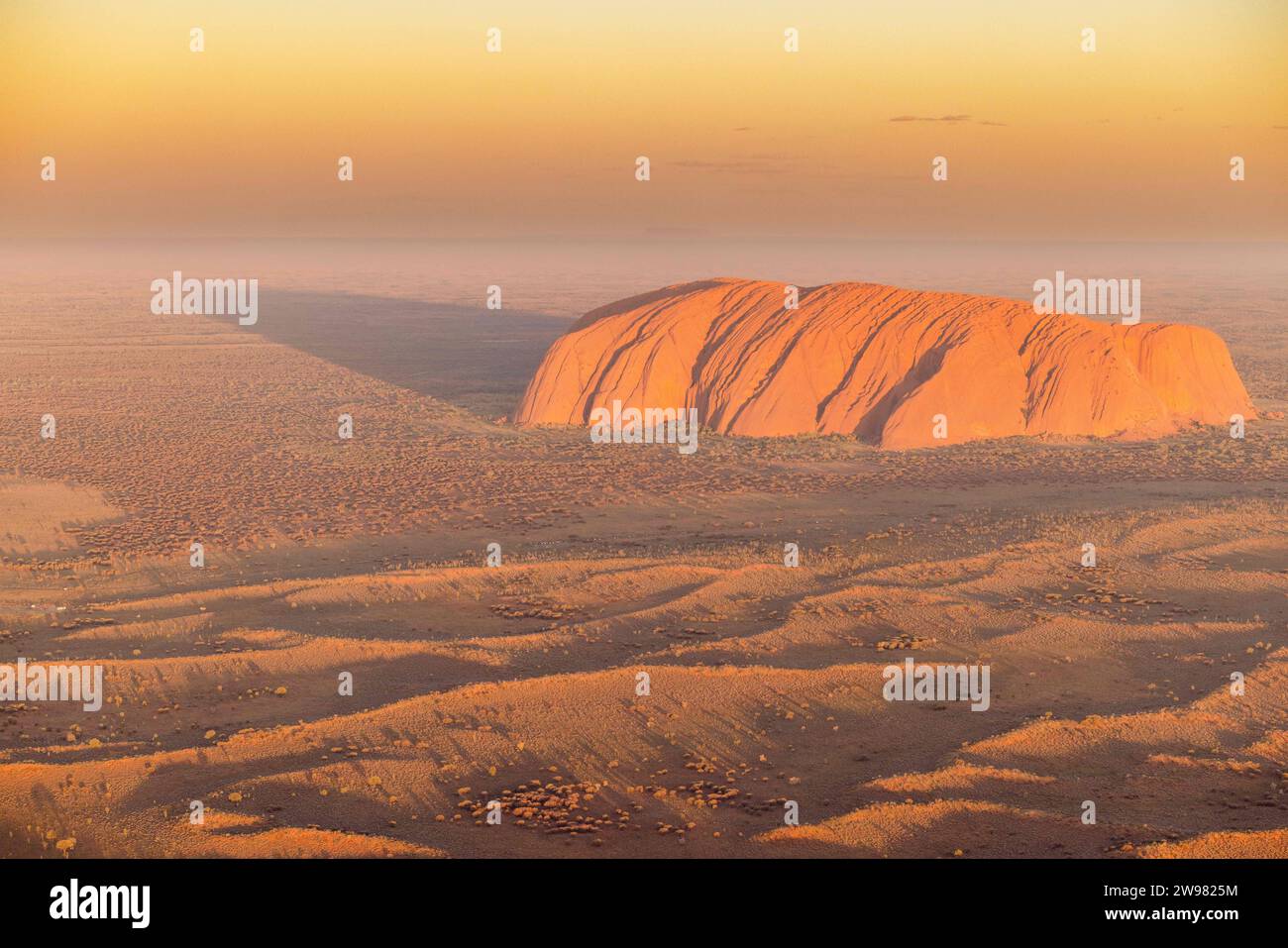 An aerial view of Uluru, a large sandstone formation in the center of ...