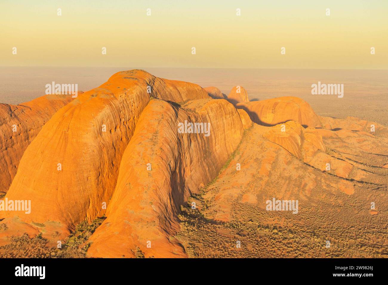 An aerial view of large sandstone formations at sunset. Uluru-Kata ...