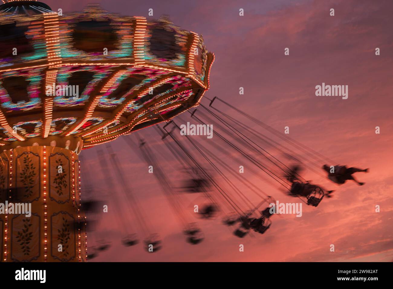 A group of people enjoying a thrilling ride in a ferris wheel with a ...