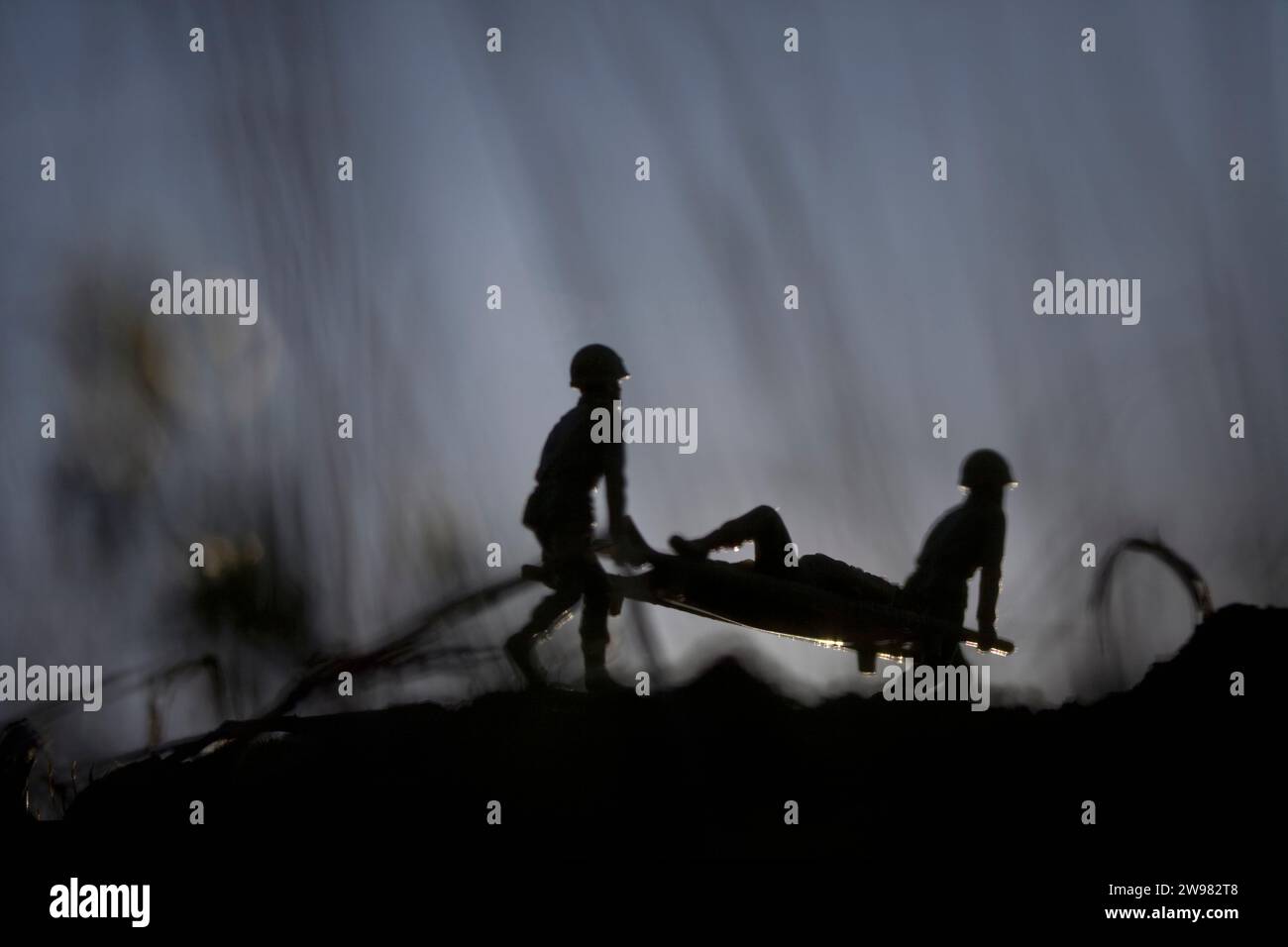 Two army soldiers carry a wounded man on a stretcher Stock Photo - Alamy