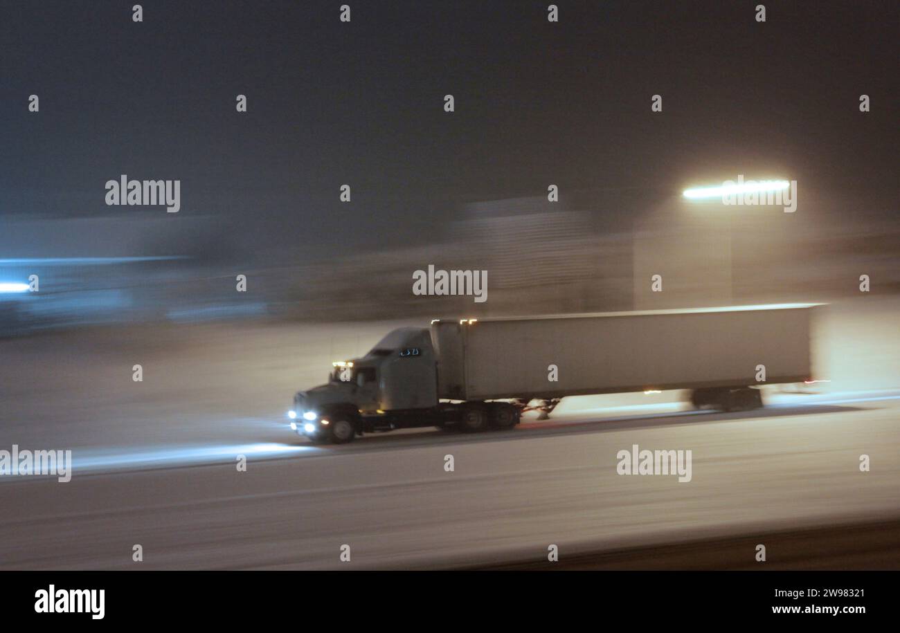 A truck speeds on a snow covered highway at night in Ashland, Oregon ...