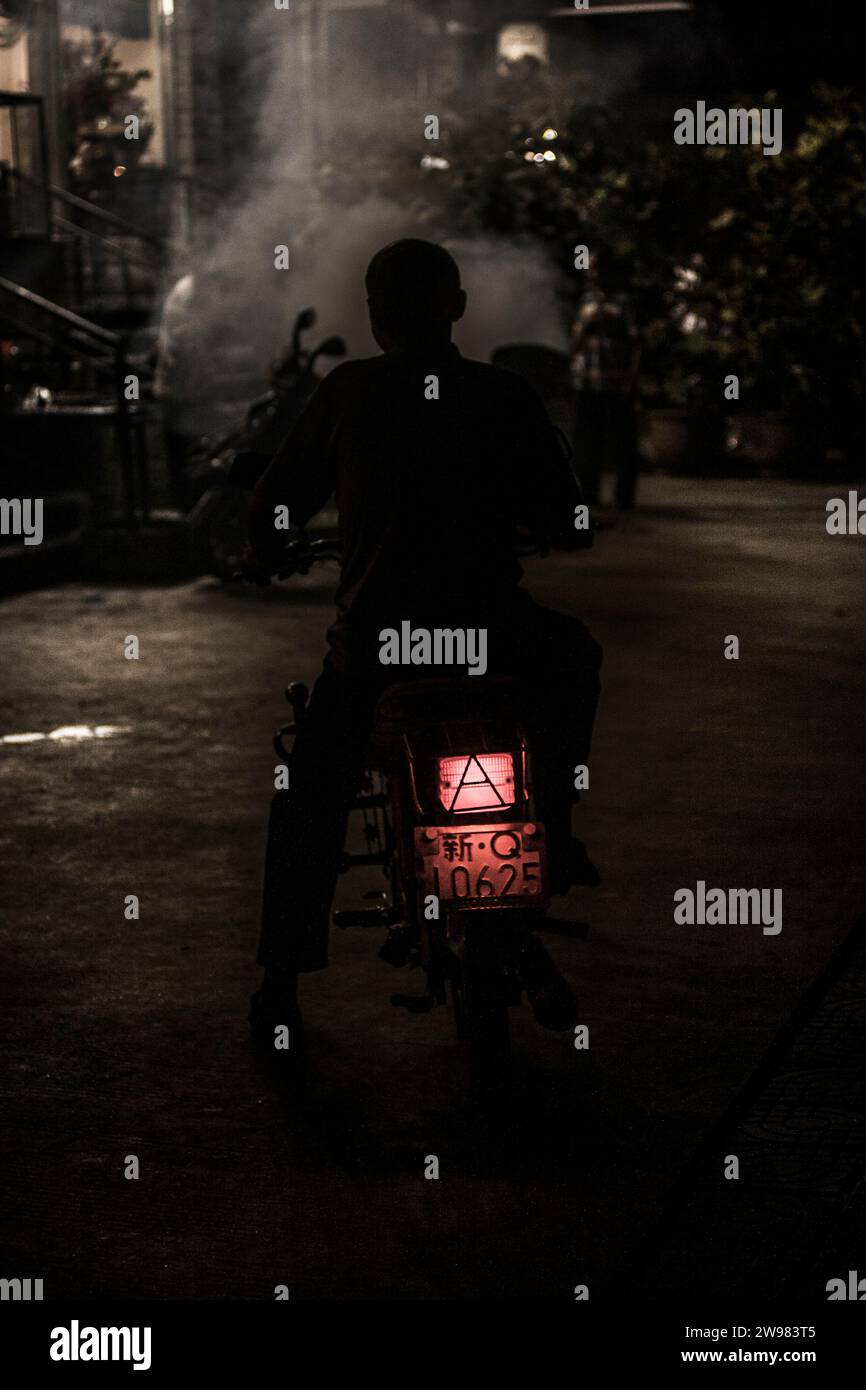 Man leaving a restaurant by motorcycle at night Stock Photo - Alamy