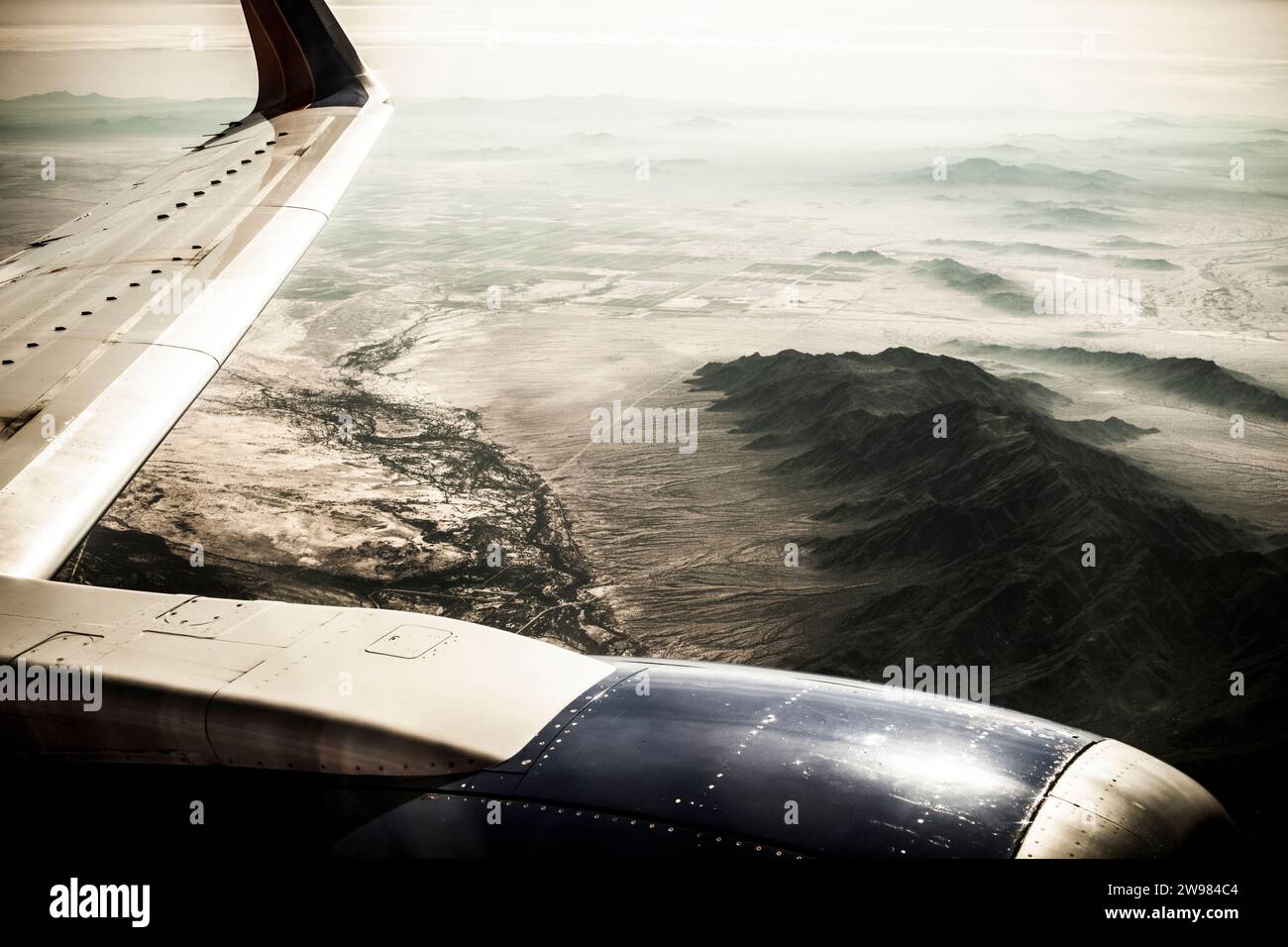 Airplane wing over a desert mountain range Stock Photo - Alamy