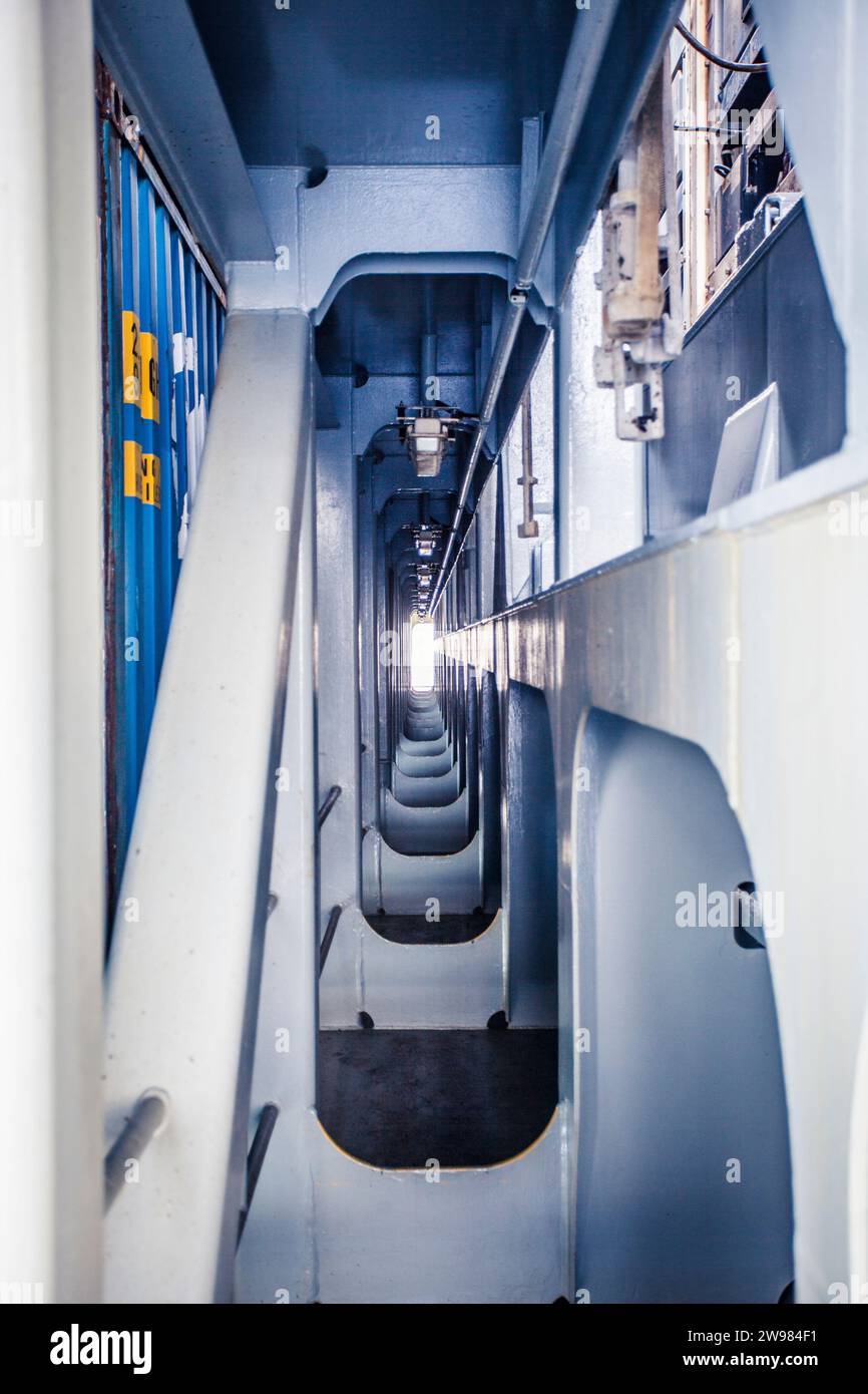 Looking across a container ship underneath stacks of containers Stock ...