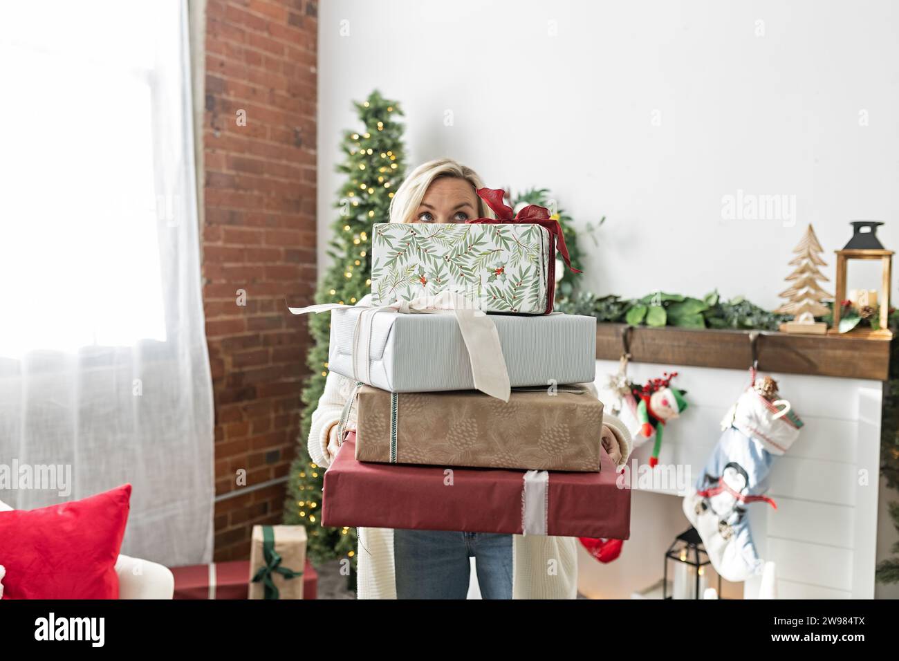 Woman holding stack of christmas gifts Stock Photo - Alamy
