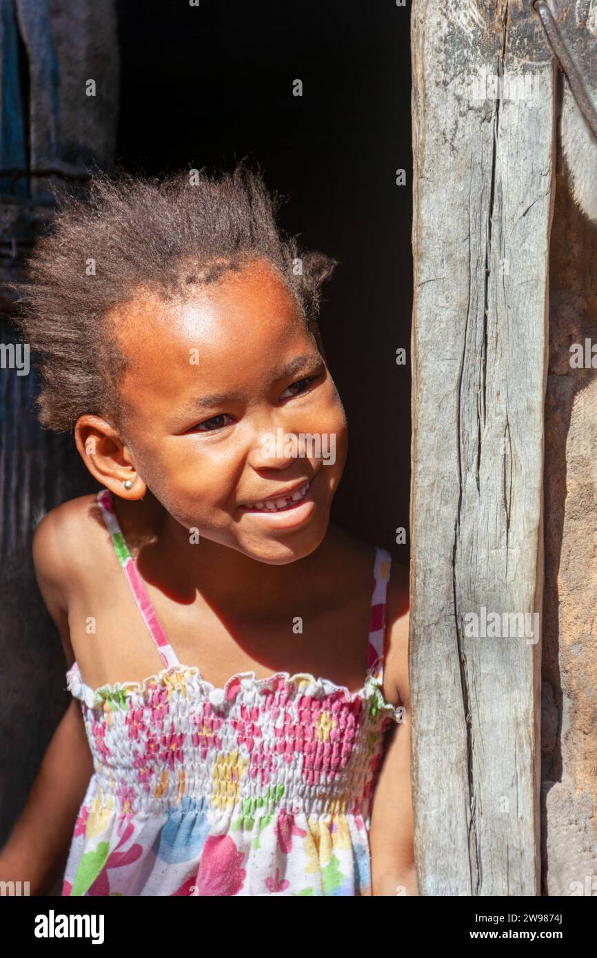 african kid standing in the door of her shack, mud house, in an ...