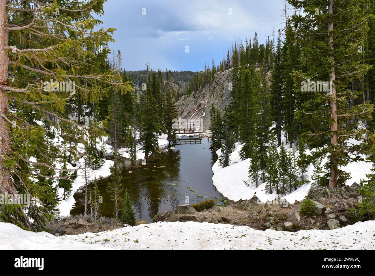 Small river flowing downstream of Lake Marie surrounded by snow and ...