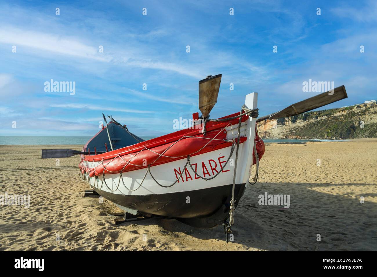 Traditional red and white painted life boat on the beach at Nazare ...