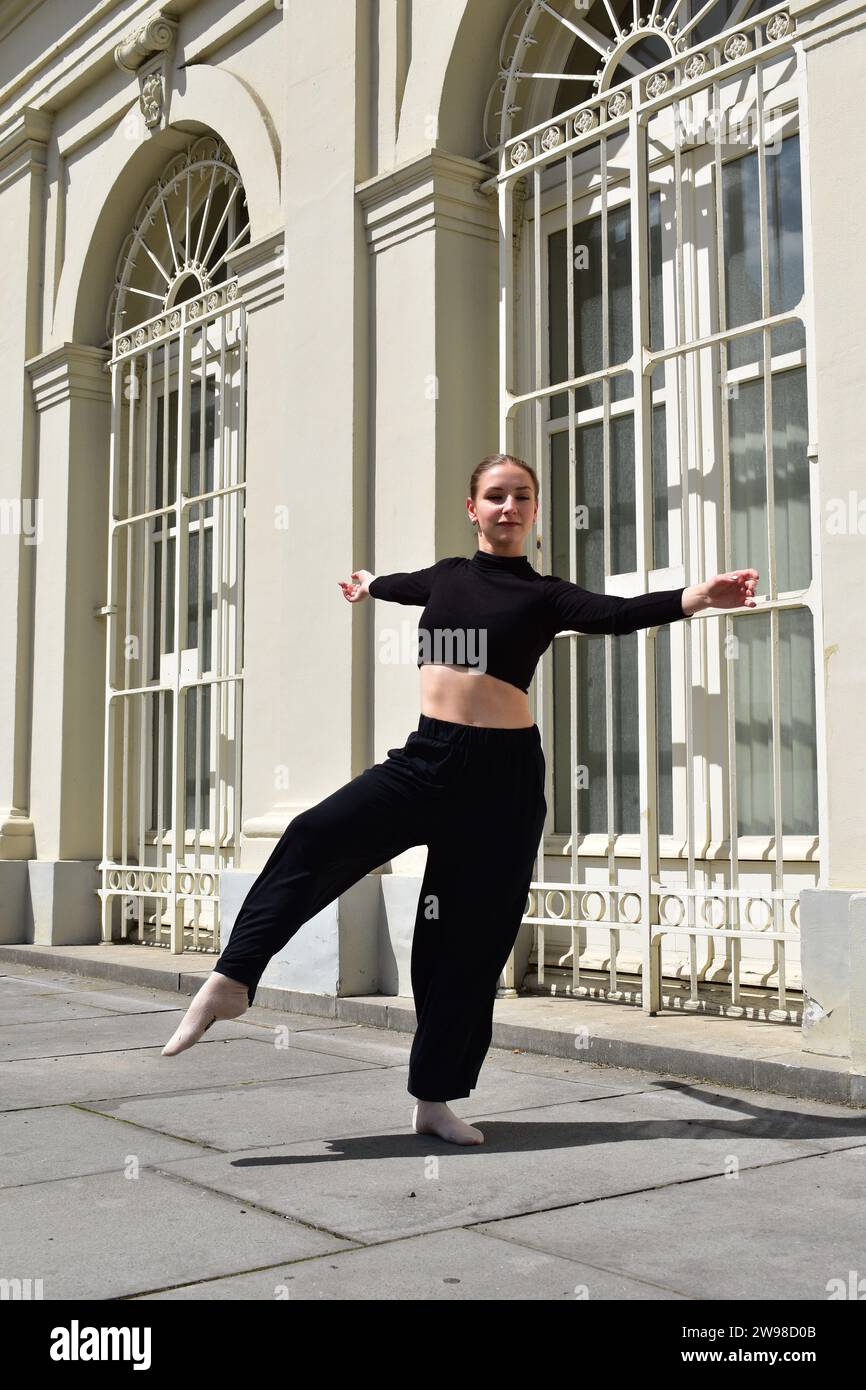 Young woman in black outfit performing a contemporary dance move in ...