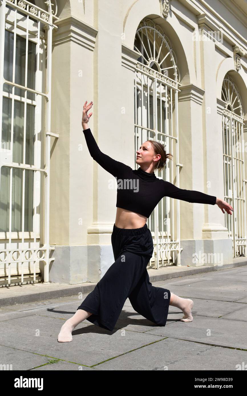 Young woman in black outfit performing a contemporary dance move in ...